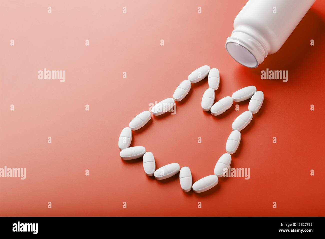 Calcium vitamin in the form of a tooth spilled out of a white jar on a ...