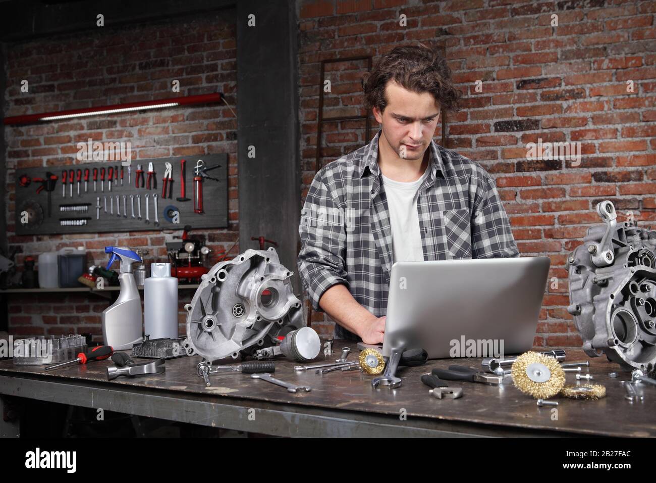 man work with computer search in internet spare engine parts on the ...