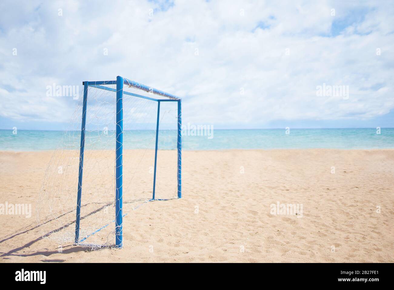 Football goal on the shore. View of the sea beach through the blue ...