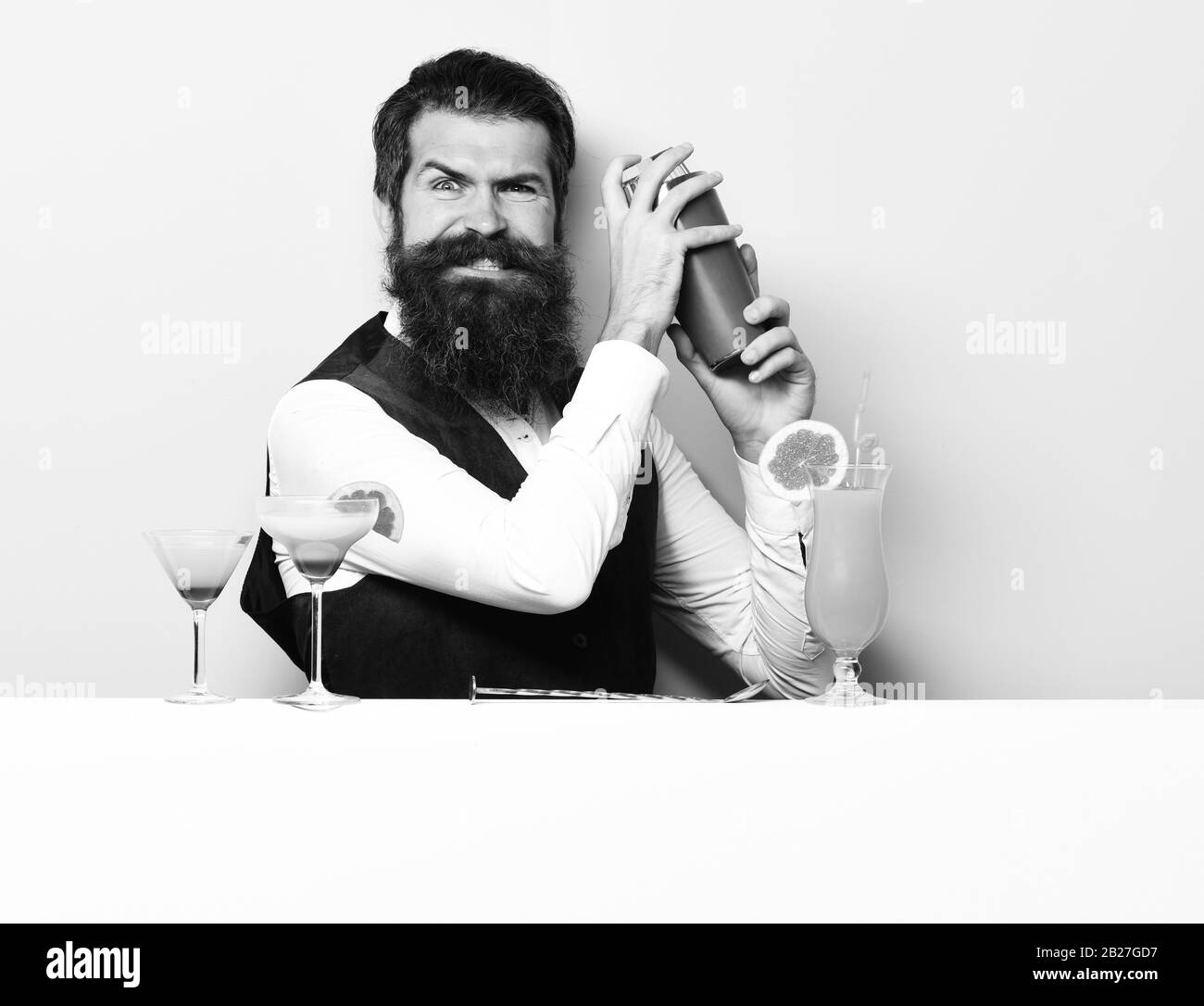 handsome bearded barman with long beard and mustache has stylish hair ...