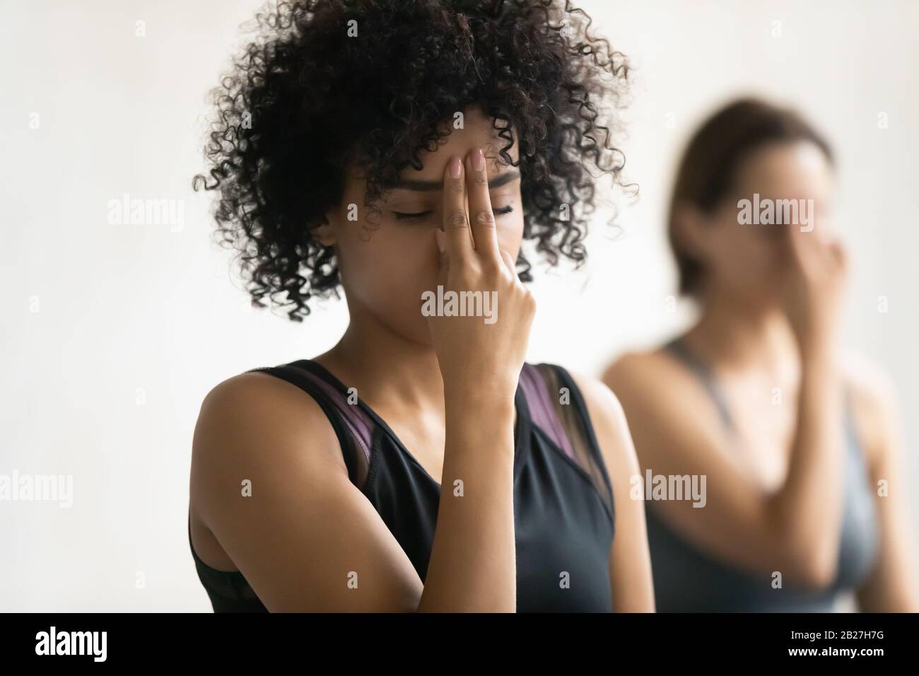 African woman during yoga class do Alternate Nostril Breathing practice ...