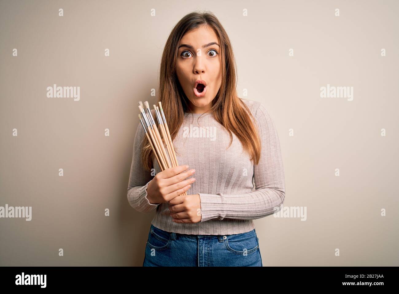 Young painter artist woman painting using paintbrush over isolated ...