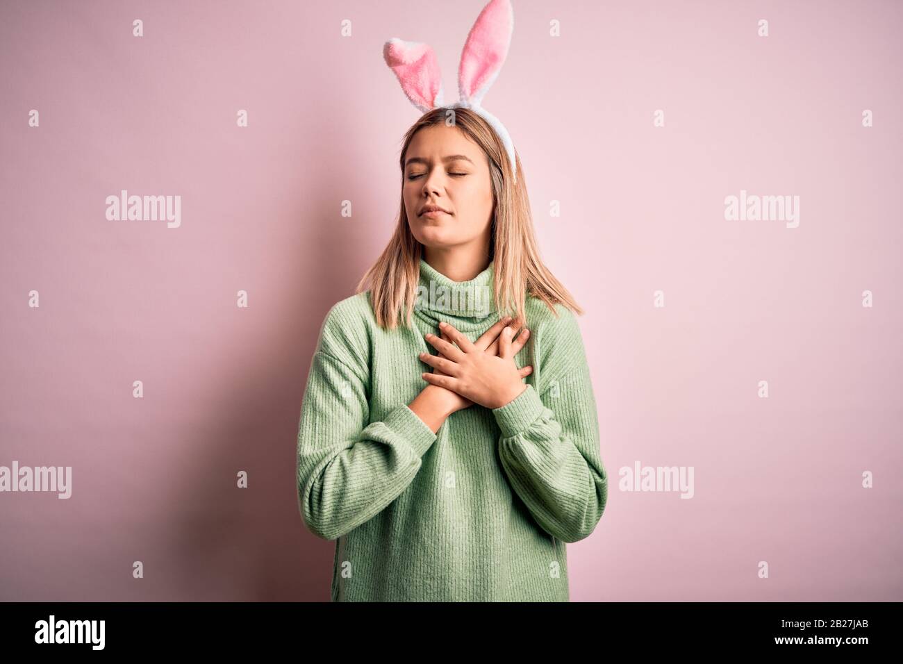 Young beautiful woman wearing easter rabbit ears standing over isolated ...