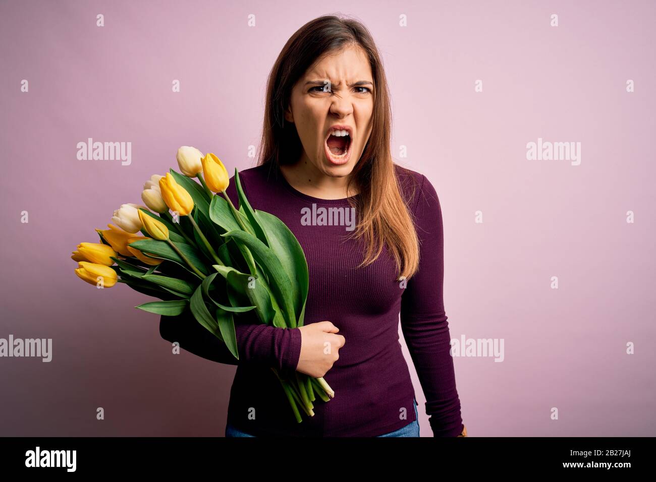 Young blonde woman holding romantic bouquet of yellow tulips flowers ...