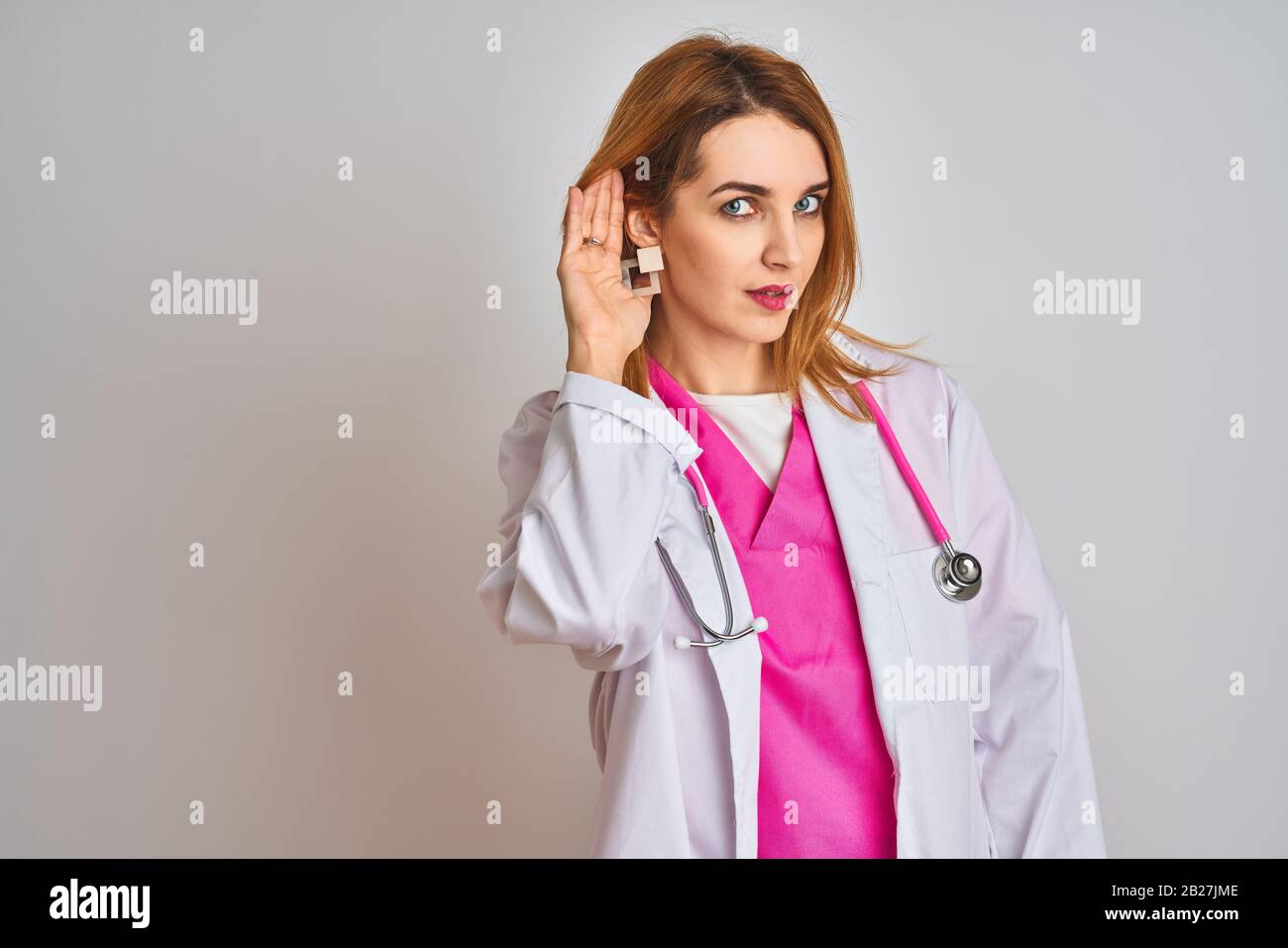 Redhead caucasian doctor woman wearing pink stethoscope over isolated ...