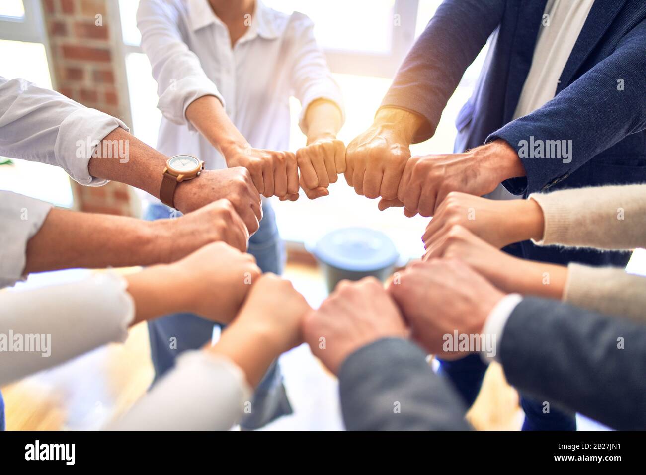 Group of business workers standing bumping fists at the office Stock ...