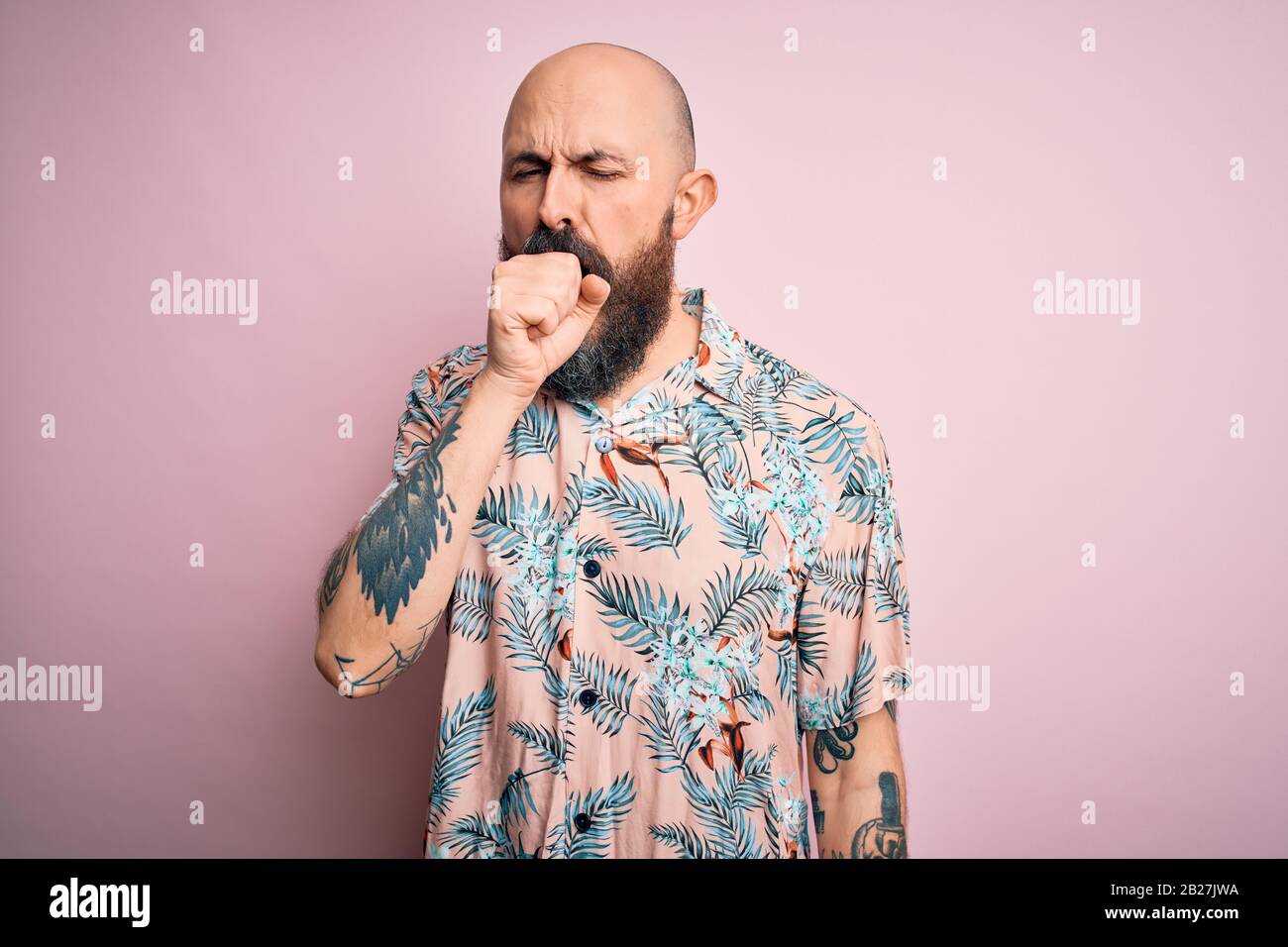 Handsome bald man with beard and tattoo wearing casual floral shirt ...