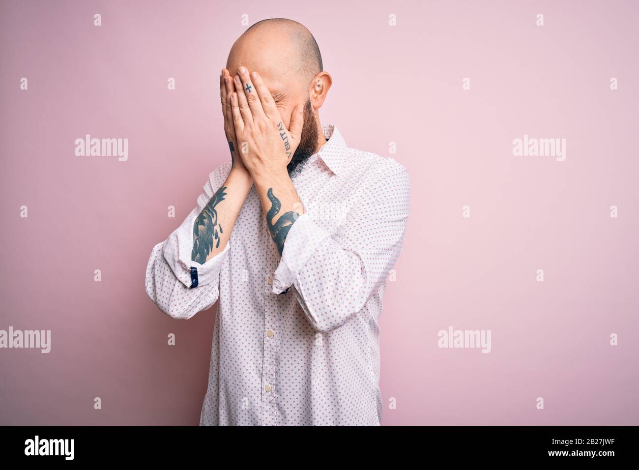 Handsome bald man with beard wearing elegant shirt over isolated pink ...