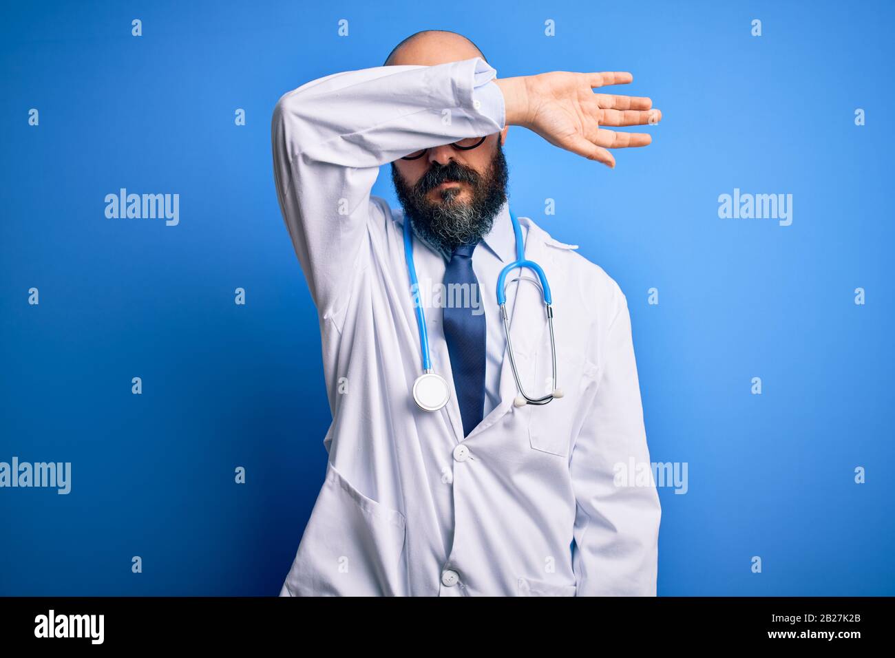 Handsome bald doctor man with beard wearing glasses and stethoscope ...