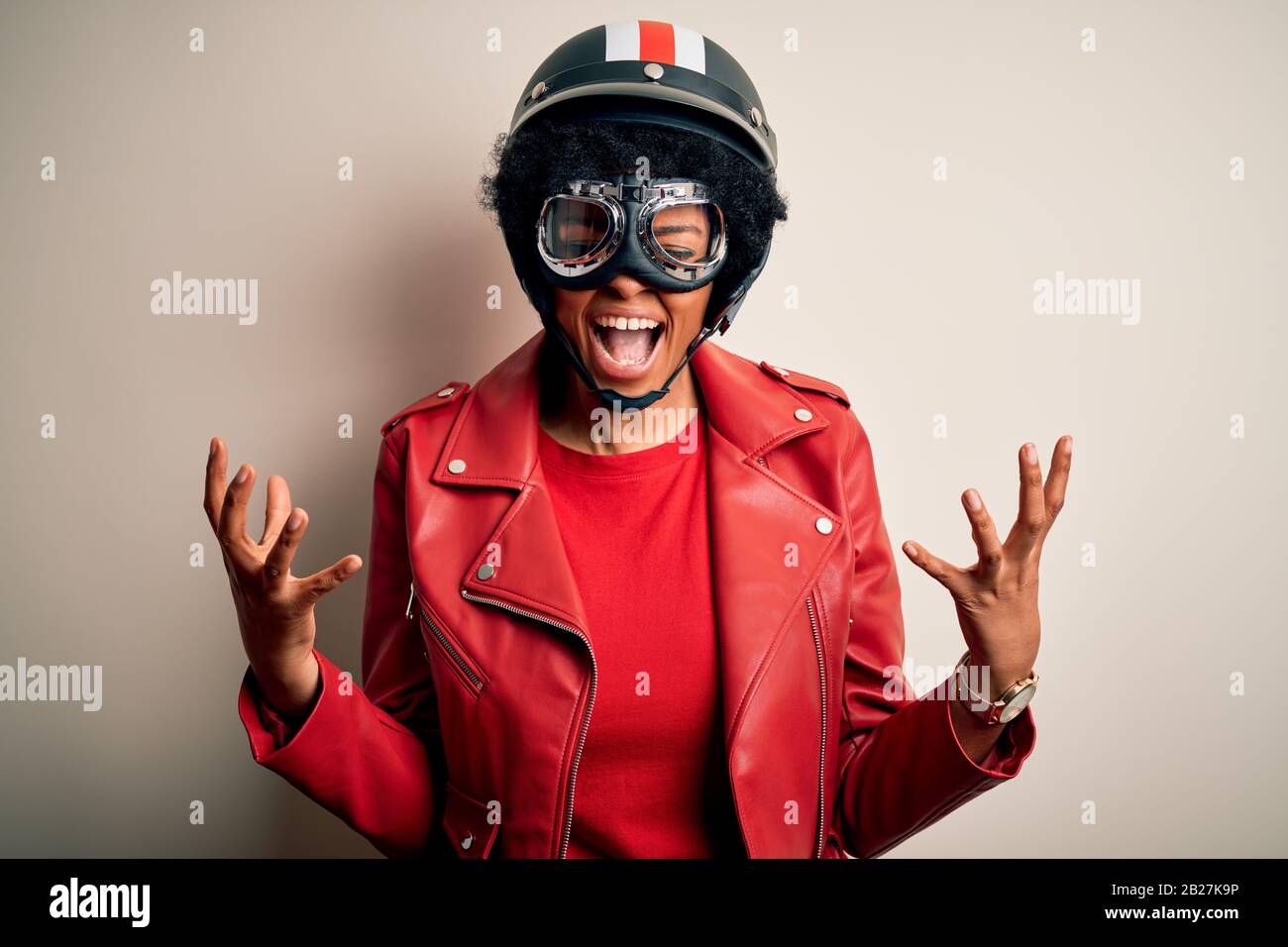 Young African American afro motorcyclist woman with curly hair wearing ...