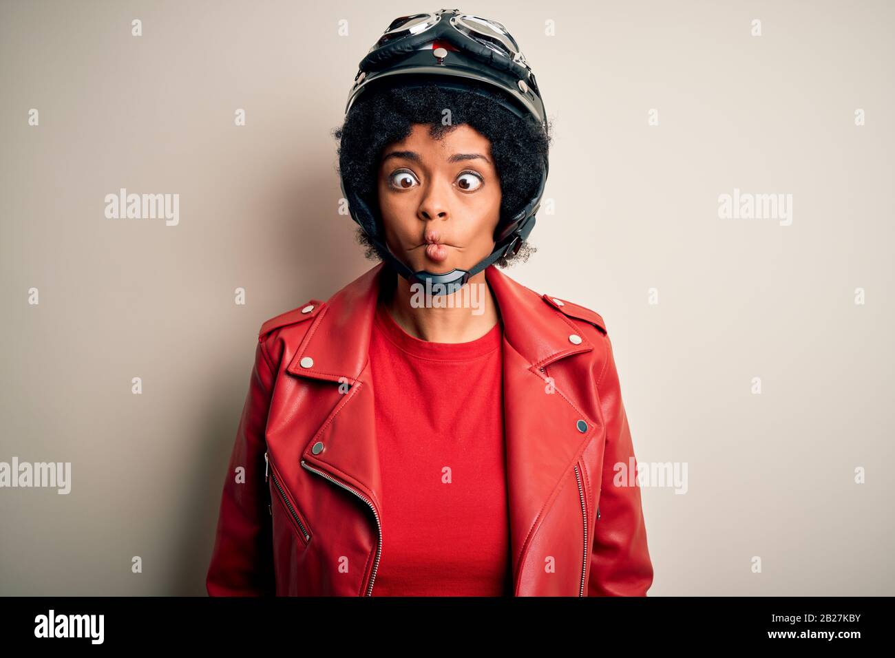 Young African American afro motorcyclist woman with curly hair wearing ...