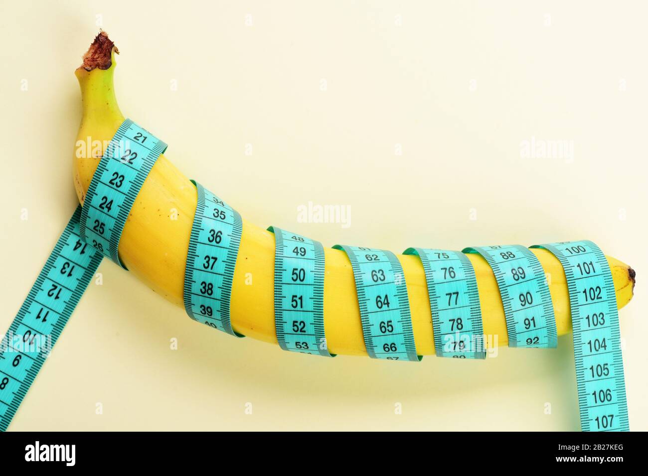 Centimeter ruler spinned around fresh fruit. Blue tape wrapped around ...