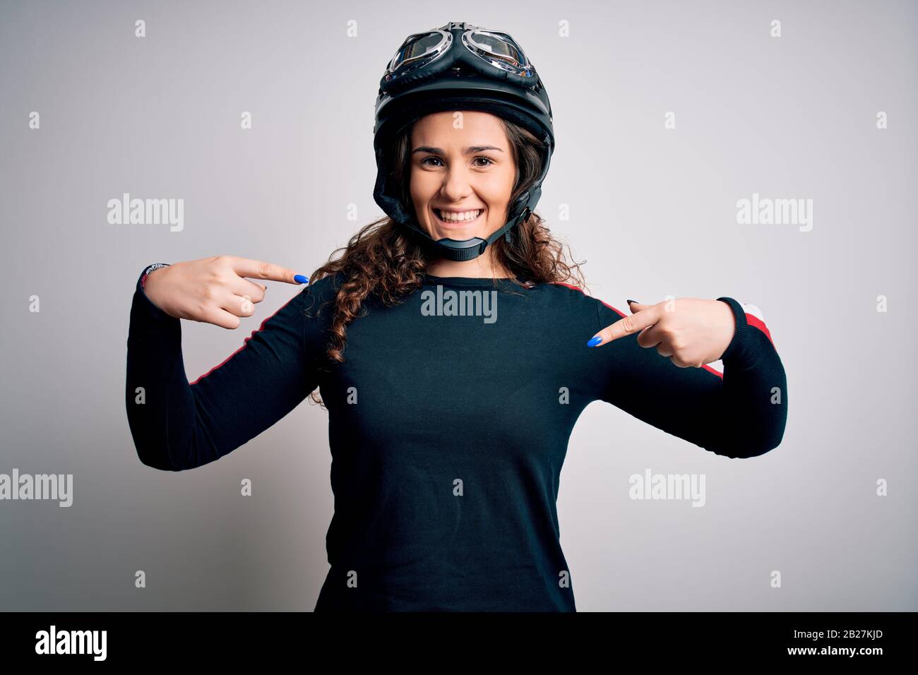 Beautiful motorcyclist woman with curly hair wearing moto helmet over ...
