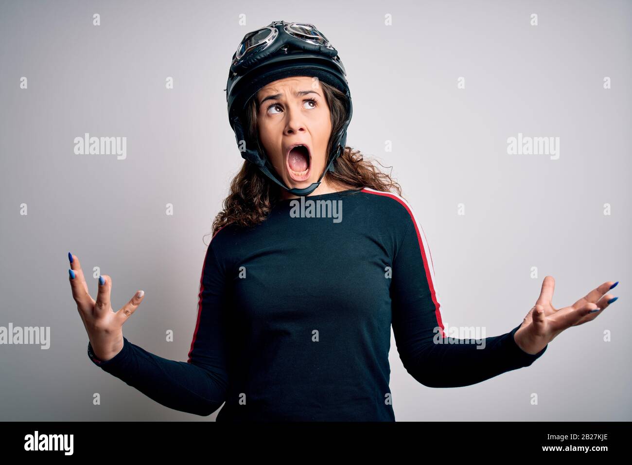 Beautiful motorcyclist woman with curly hair wearing moto helmet over ...