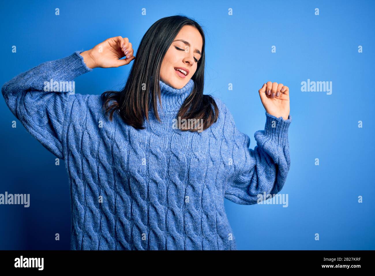 Young brunette woman with blue eyes wearing casual turtleneck sweater ...