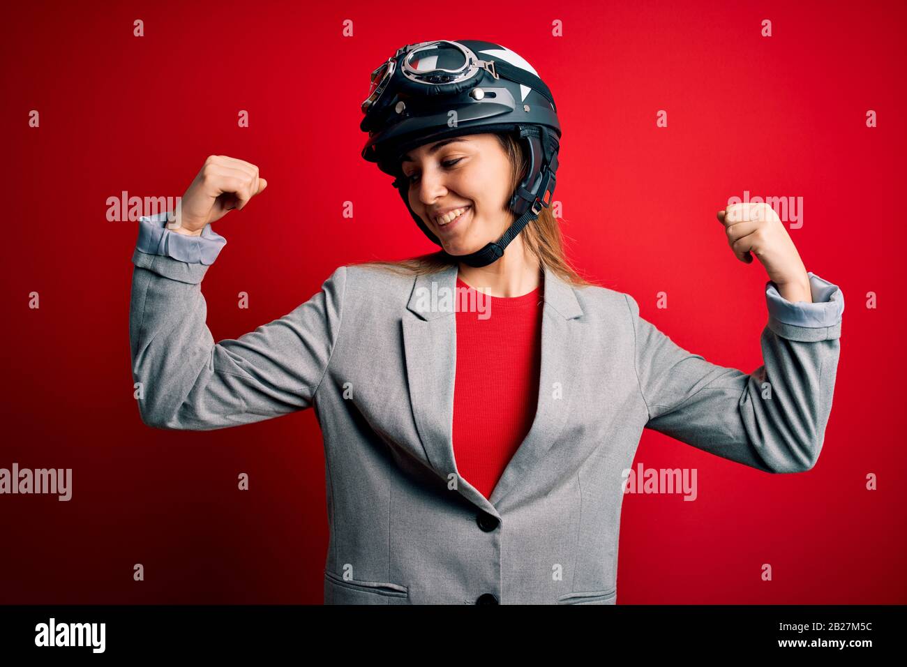 Young beautiful blonde motorcyclist woman wearing motorcycle helmet ...