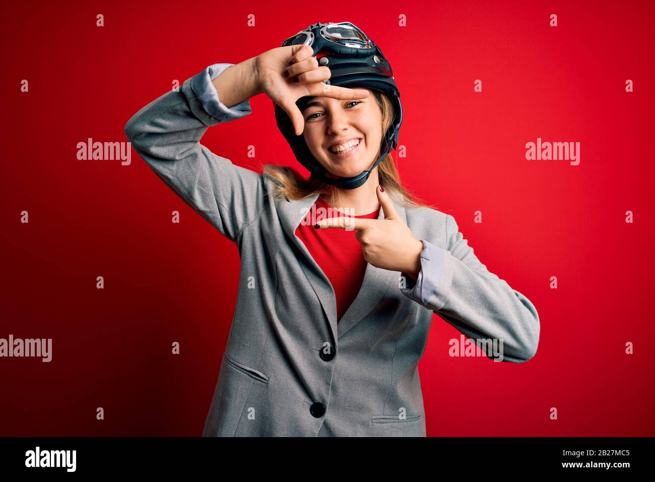Young beautiful blonde motorcyclist woman wearing motorcycle helmet ...