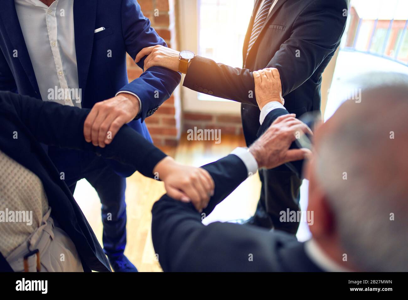 Group of business workers standing on a circle doing symbol with hands ...