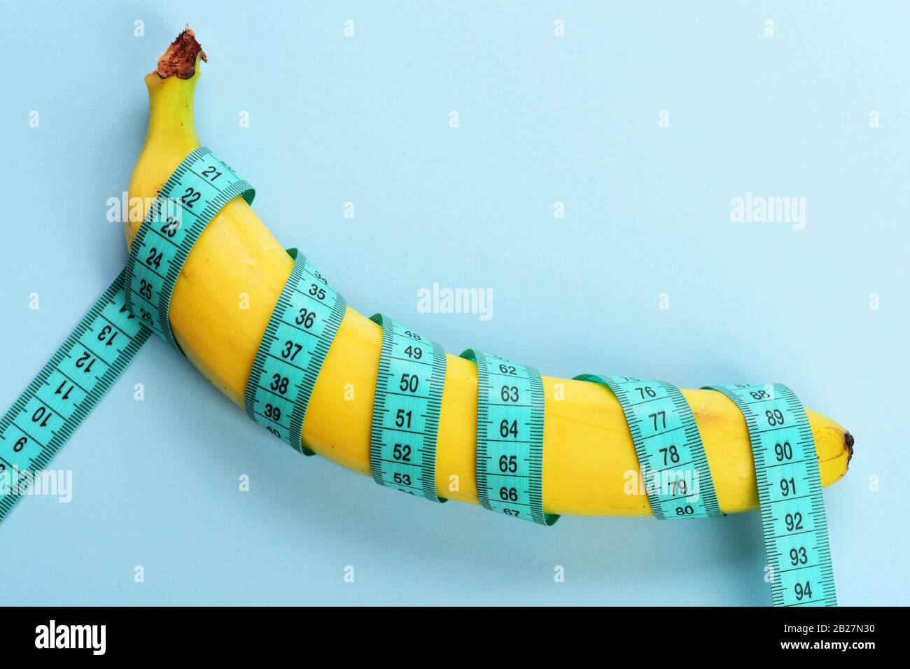 Centimeter ruler spinned around fruit. Banana with blue tape for ...
