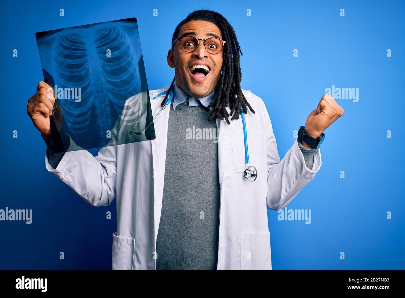 Young african american afro doctor man with dreadlocks holding chest ...