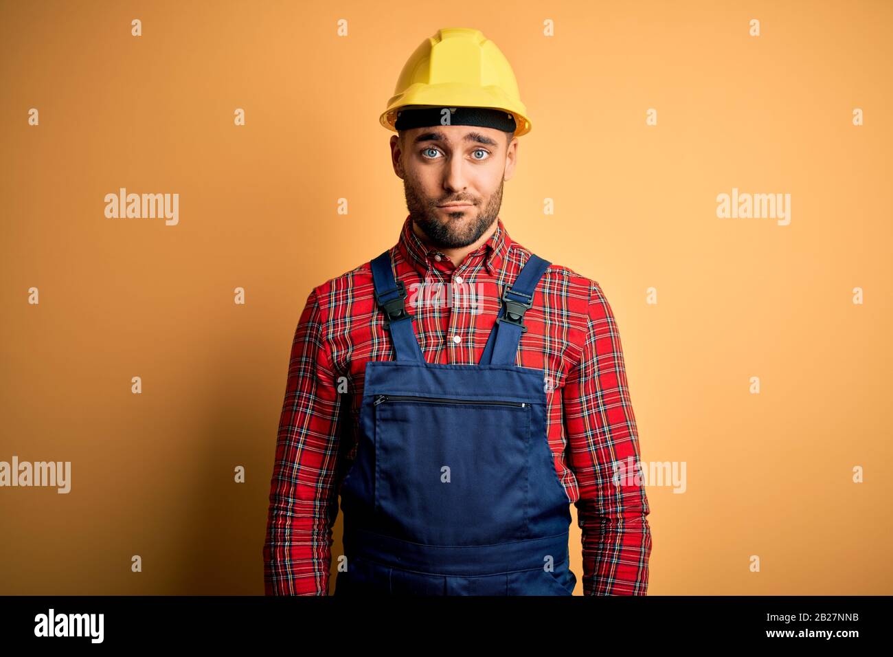 Young builder man wearing construction uniform and safety helmet over ...