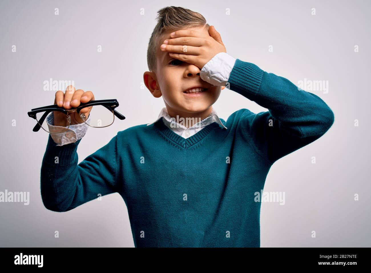 Young little caucasian kid holding eyesight glasses correction over ...