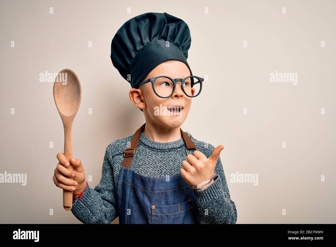 Young little caucasian cook kid wearing chef uniform and hat cooking ...