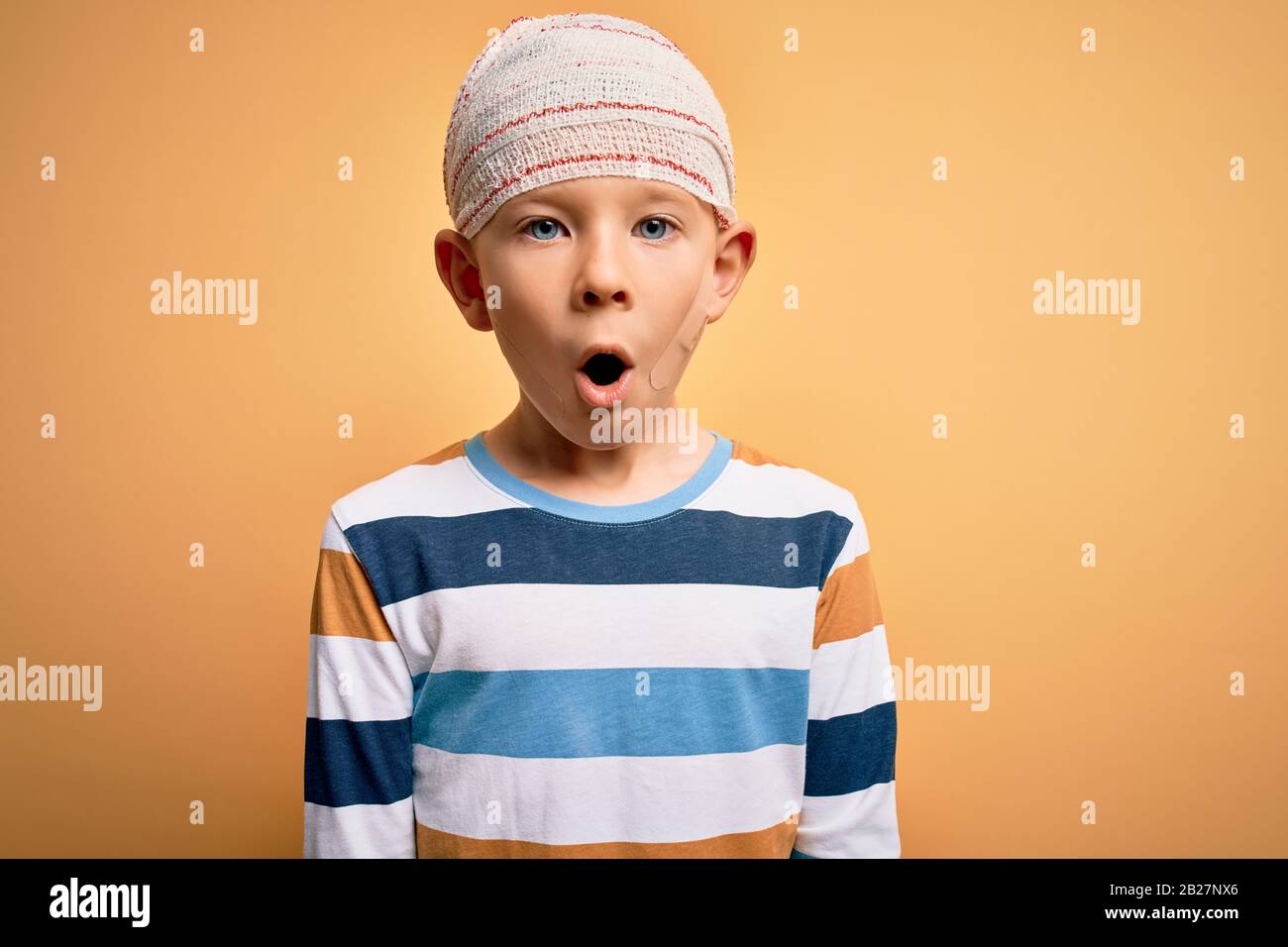 Young little caucasian kid injured wearing medical bandage on head over ...