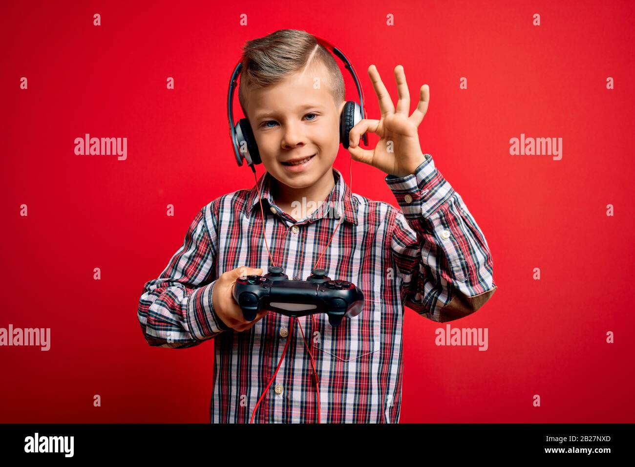Young little caucasian gamer kid playing video games using gamepad ...
