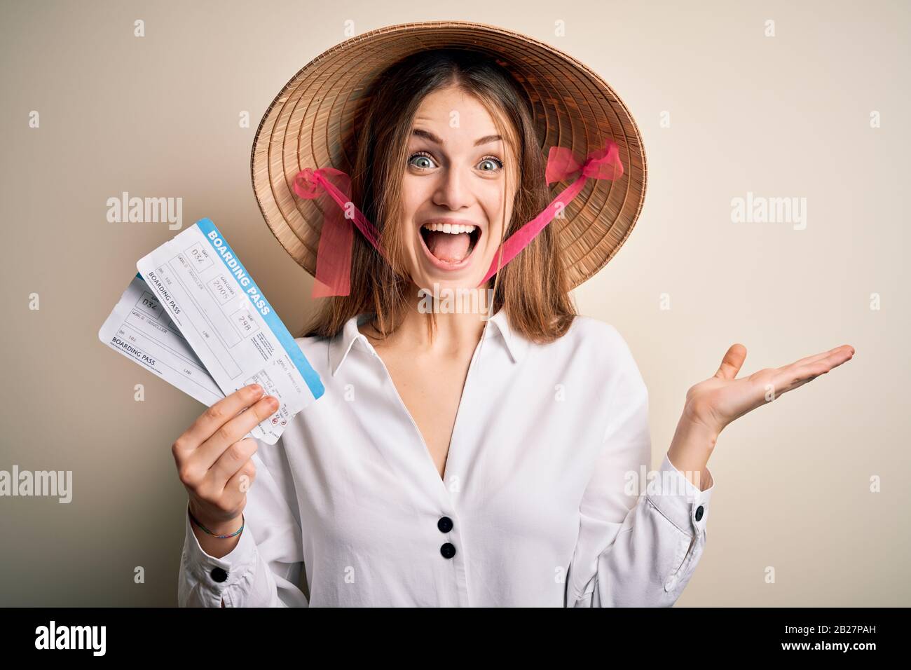 Young beautiful redhead tourist woman wearing asian traditional hat ...
