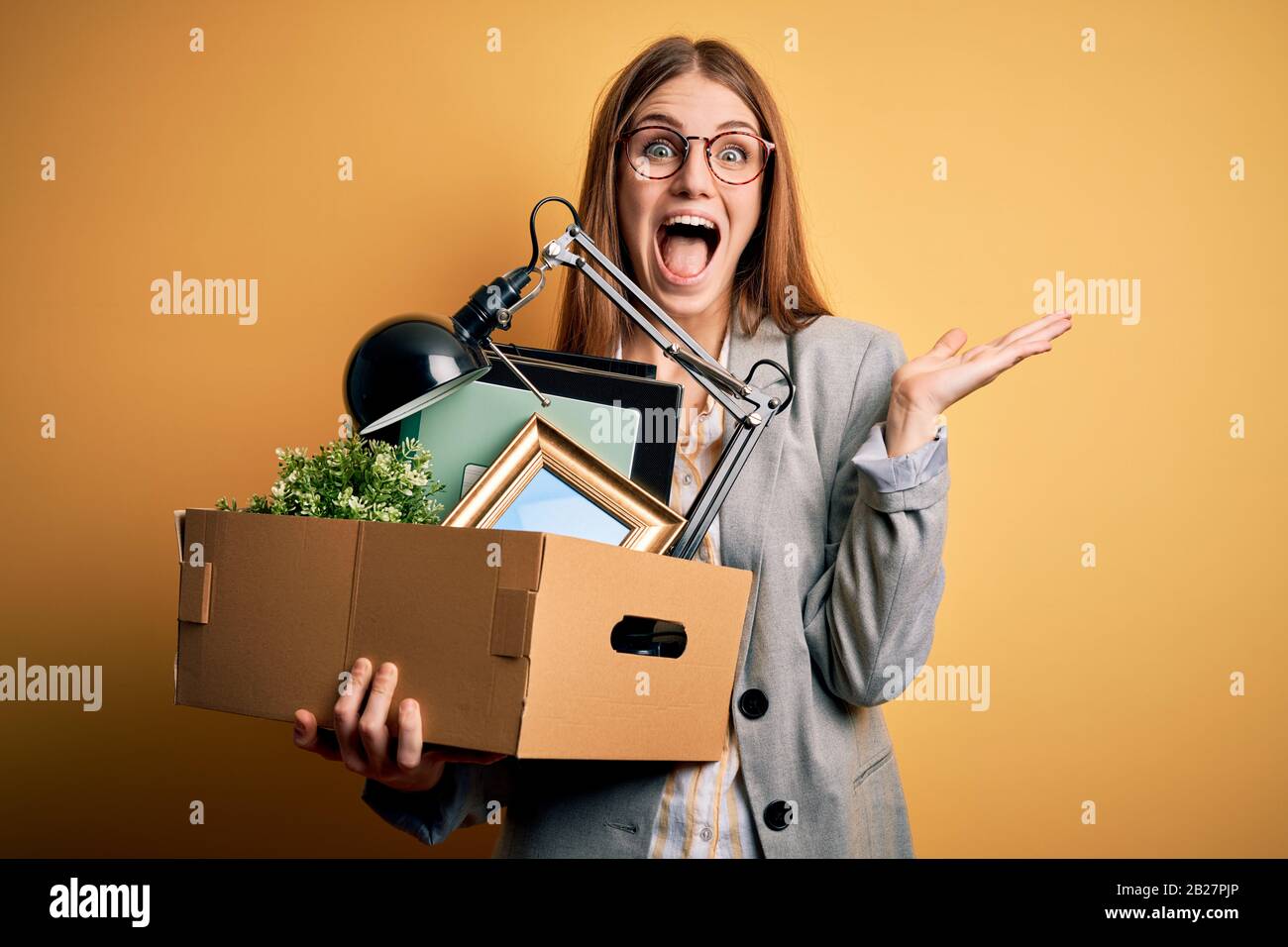 Young beautiful redhead businesswoman fired holding carboard box over ...