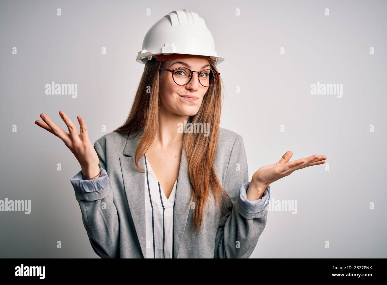 Young beautiful redhead architect woman wearing security helmet over ... Young beautiful redhead architect woman wearing security helmet over ...