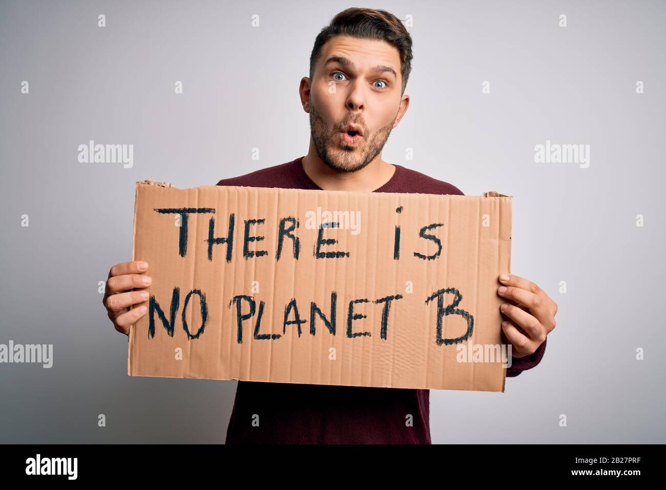 Young activist man holding protest banner for climate change and ...