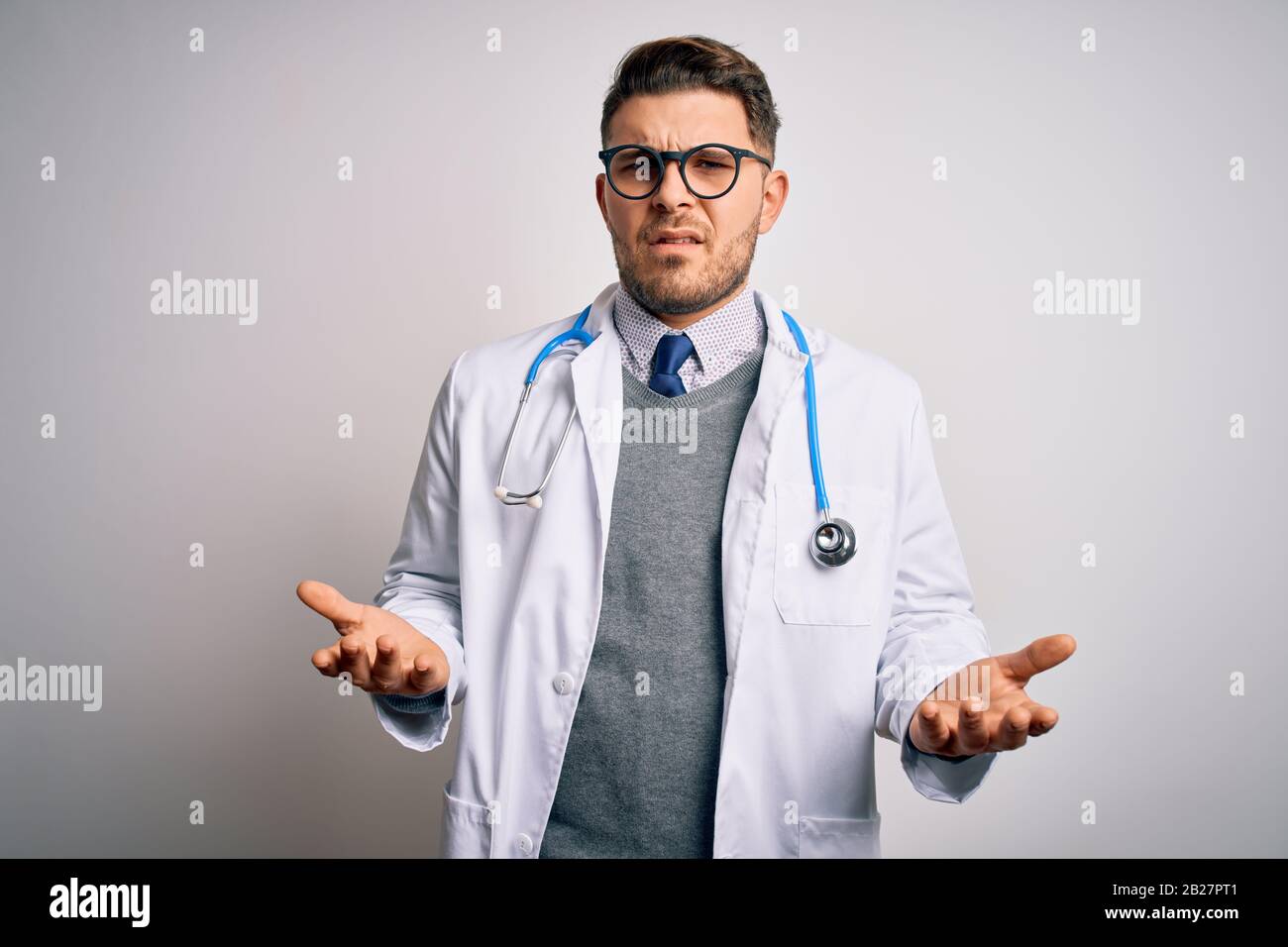 Young doctor man with blue eyes wearing medical coat and stethoscope ...