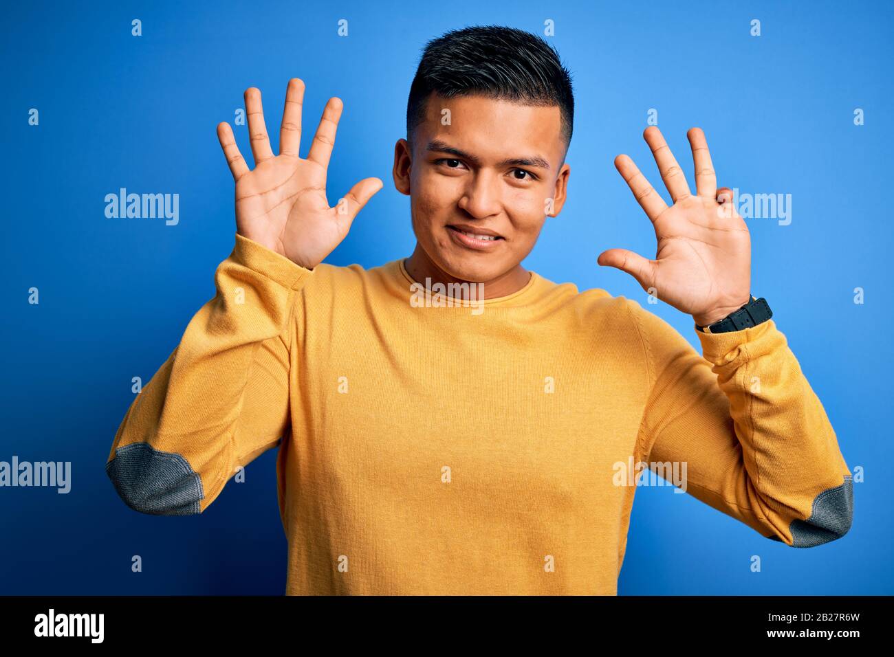 Young handsome latin man wearing yellow casual sweater over isolated ... Young handsome latin man wearing yellow casual sweater over isolated ...