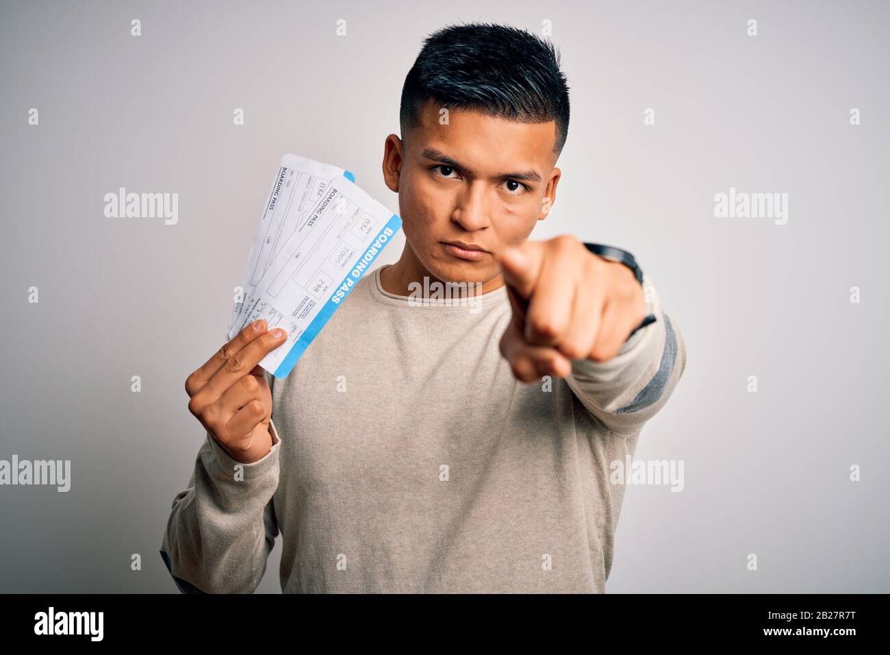 Young handsome latin tourist man on vacation holding airline boarding ...