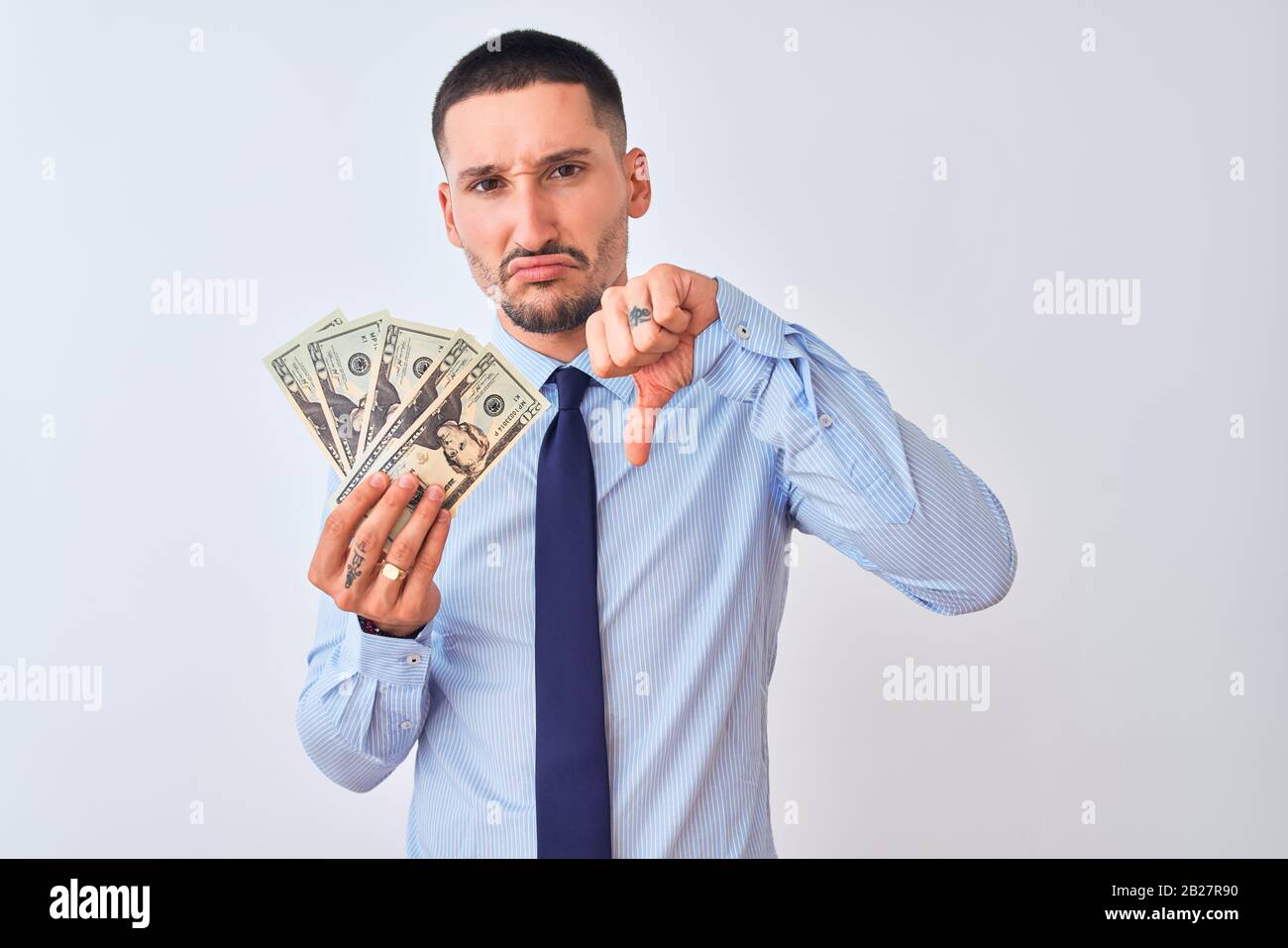 Young handsome business man holding a bunch of bank notes dollars over ...