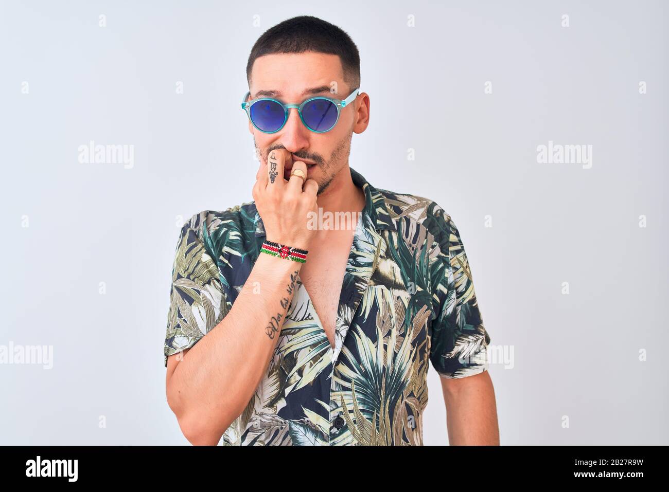 Young handsome man wearing Hawaiian sumer shirt and blue sunglasses ...