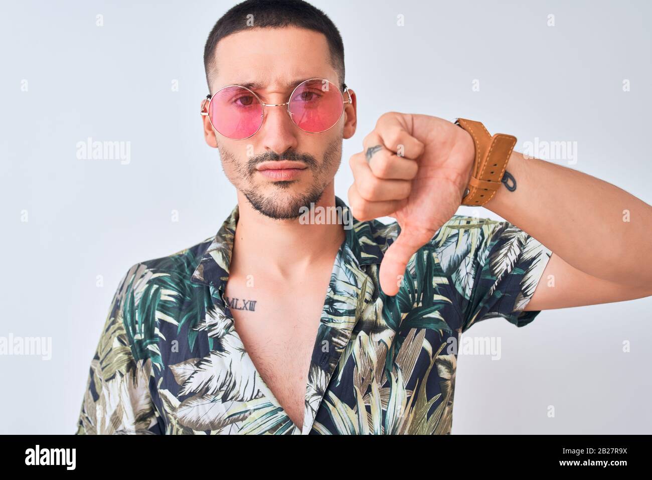 Young handsome man wearing Hawaiian sumer shirt and pink sunglasses ...