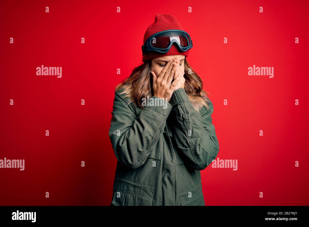 Young blonde girl wearing ski glasses and winter coat for ski weather ...