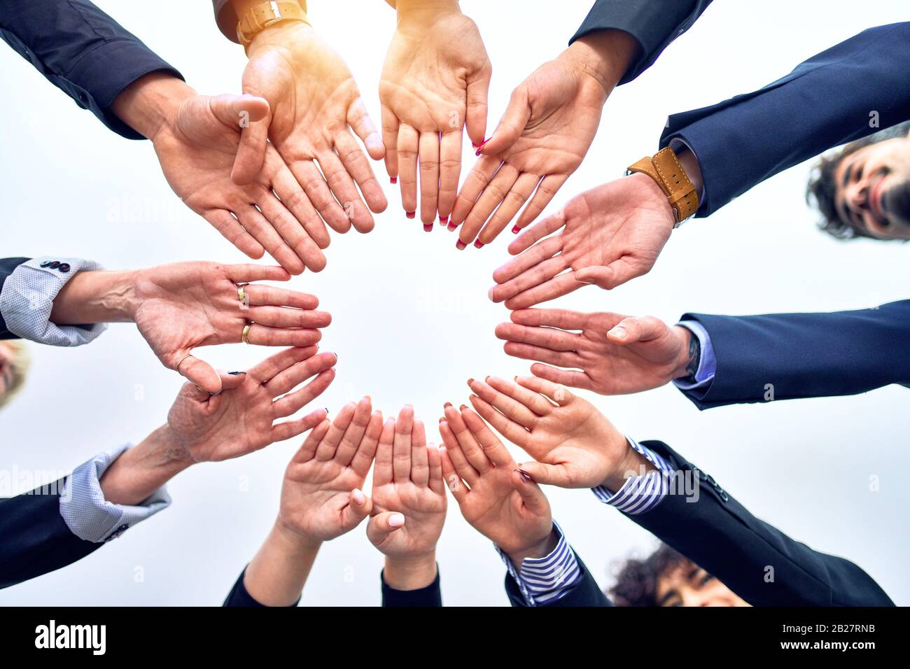 Group of business workers standing with hands together at the office ...