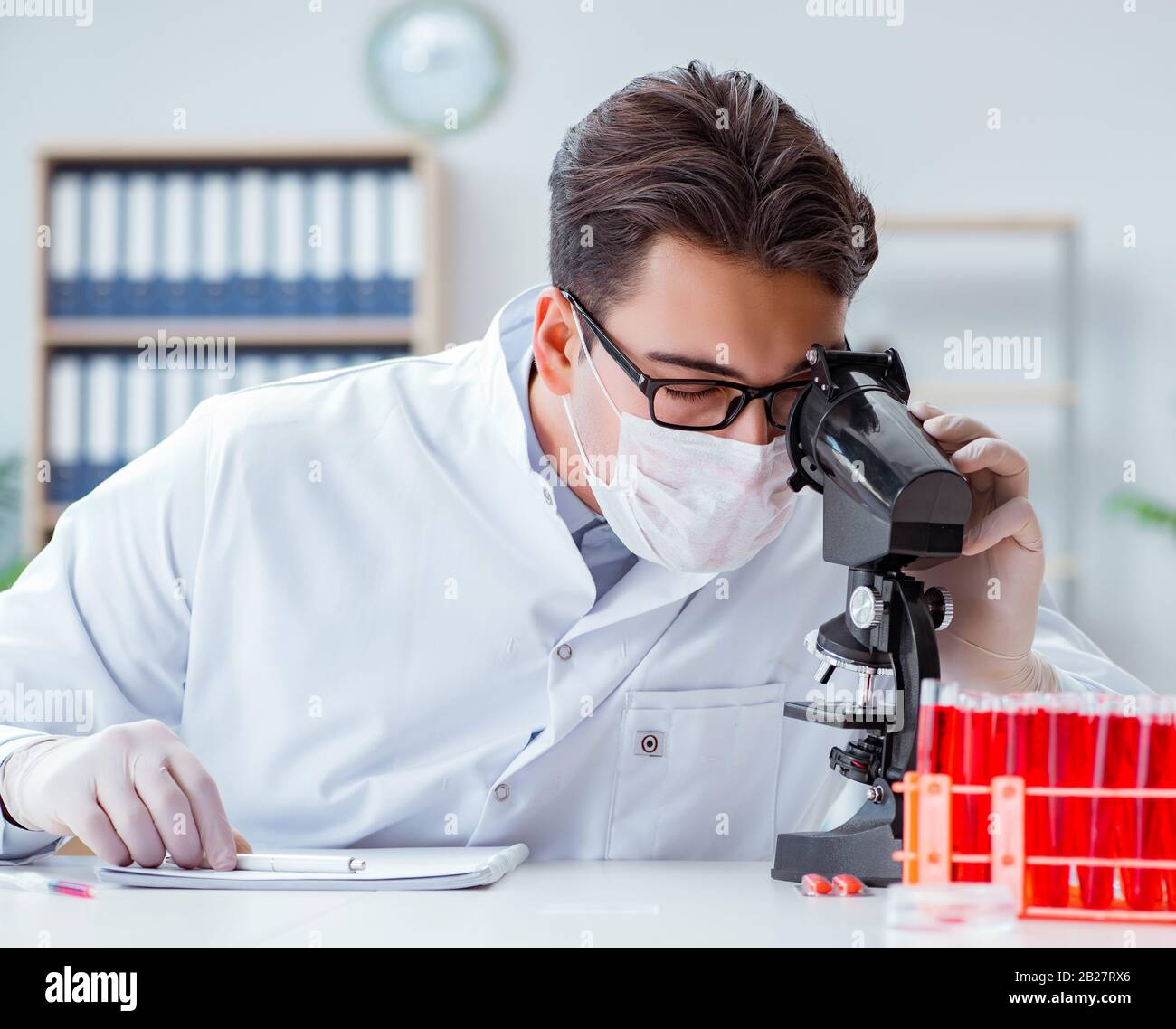 The young doctor working in the lab with microscope Stock Photo - Alamy