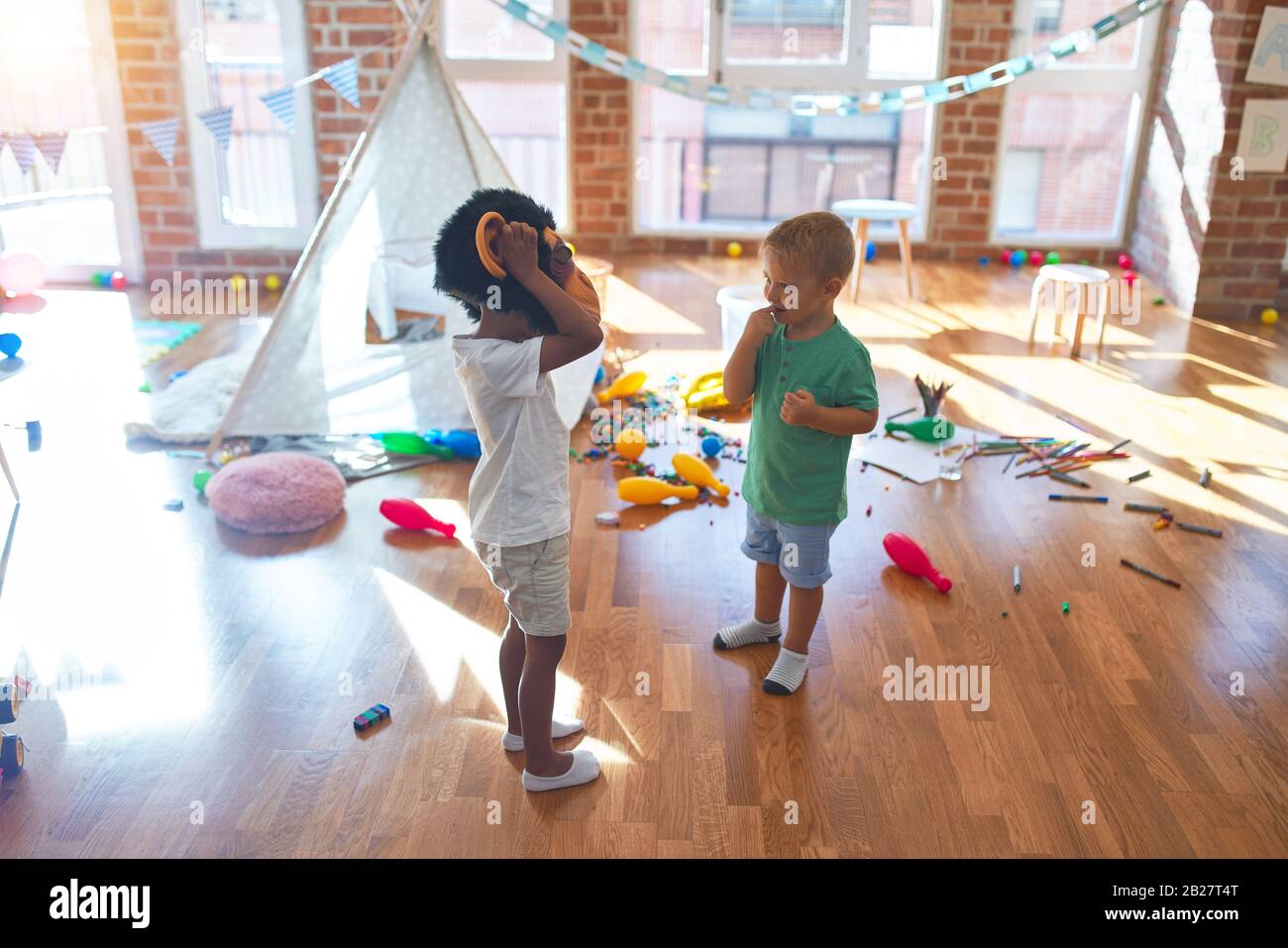Adorable toddlers playing around lots of toys at kindergarten Stock ...