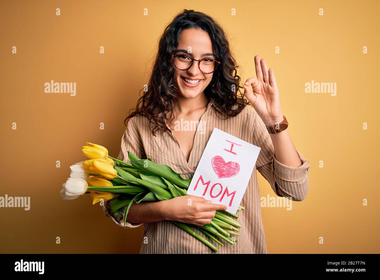 Beautiful curly hair woman holding love mom message and tulips ...