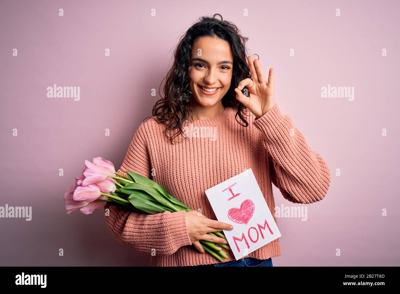 Beautiful curly hair woman holding love mom message and tulips ...