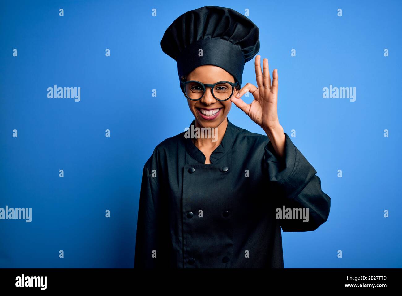 Young african american chef woman wearing cooker uniform and hat over ...