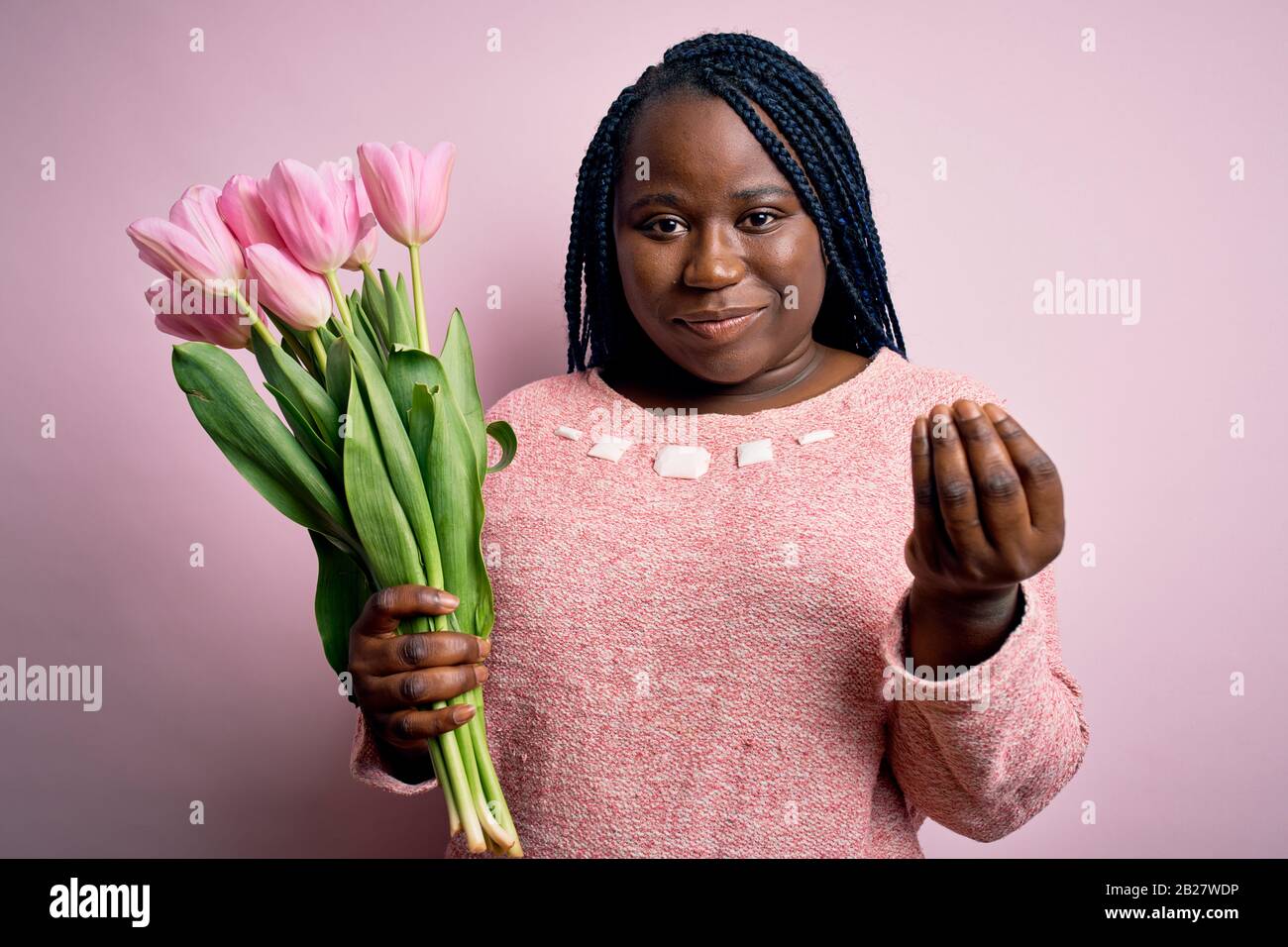 Young african american plus size woman with braids holding bouquet of ...