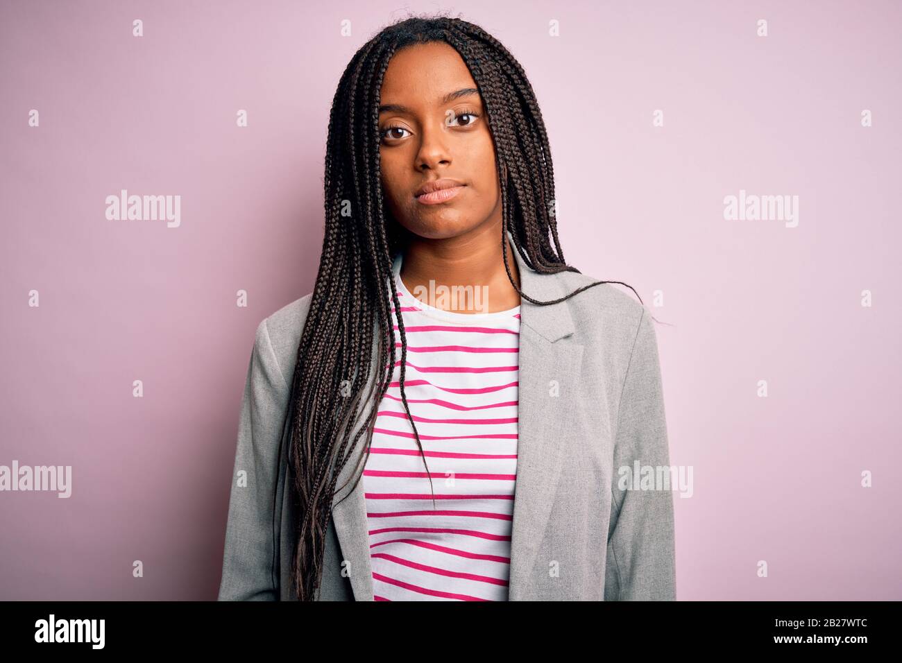 Young african american business woman standing over pink isolated ...