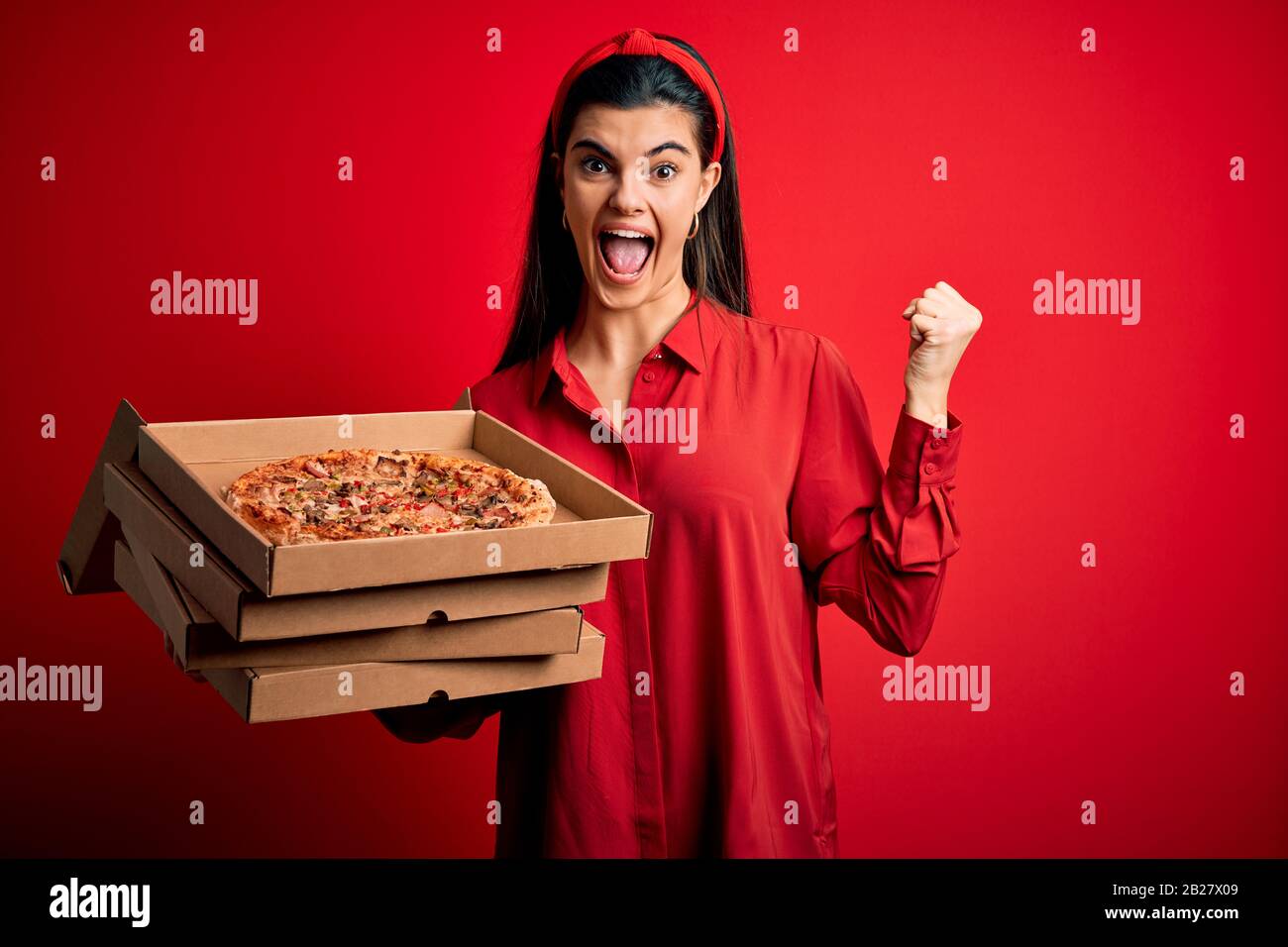 Young beautiful brunette woman holding delivery boxes with Italian ...