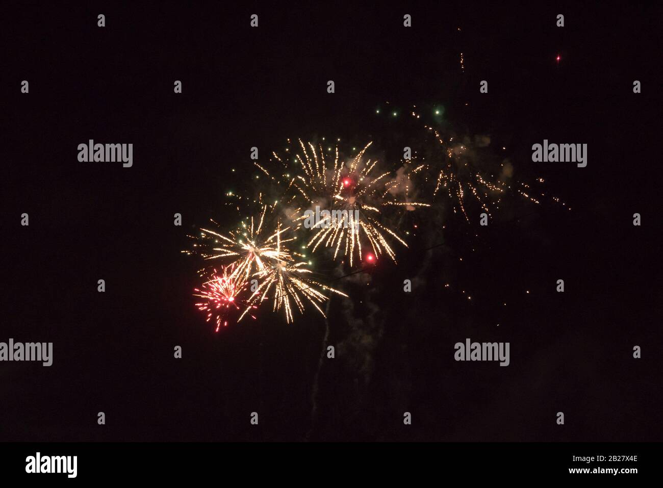 Small, single, fireworks in a black, night sky. Small, single ...